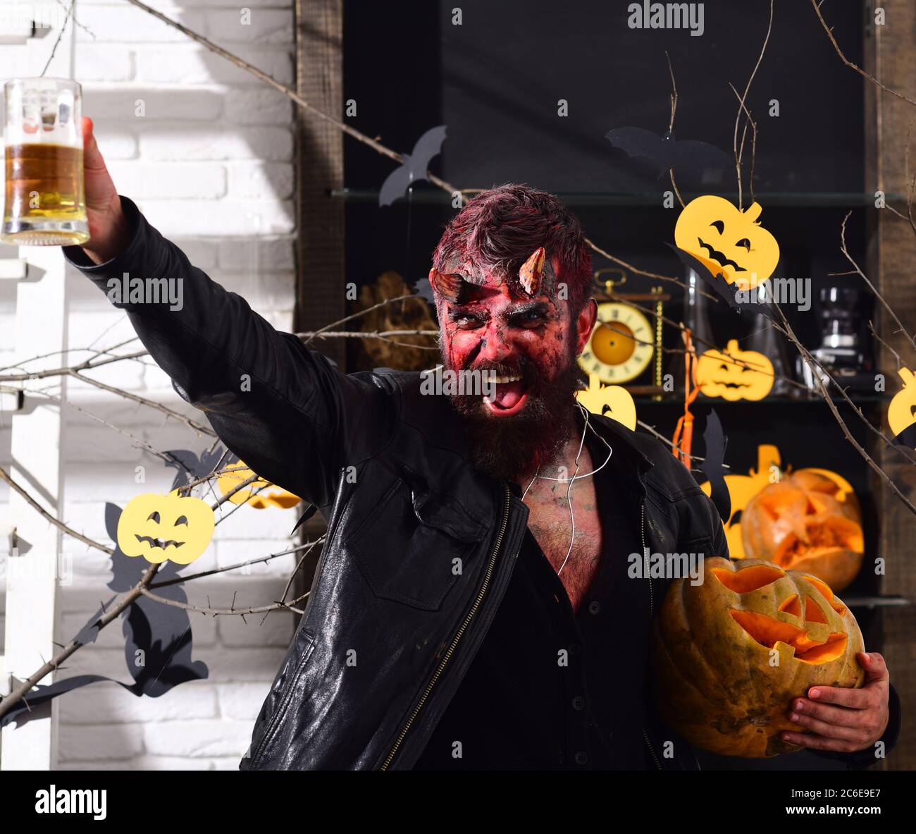 Demon with horns and smiling evil face holds jack o lantern. Devil or ...