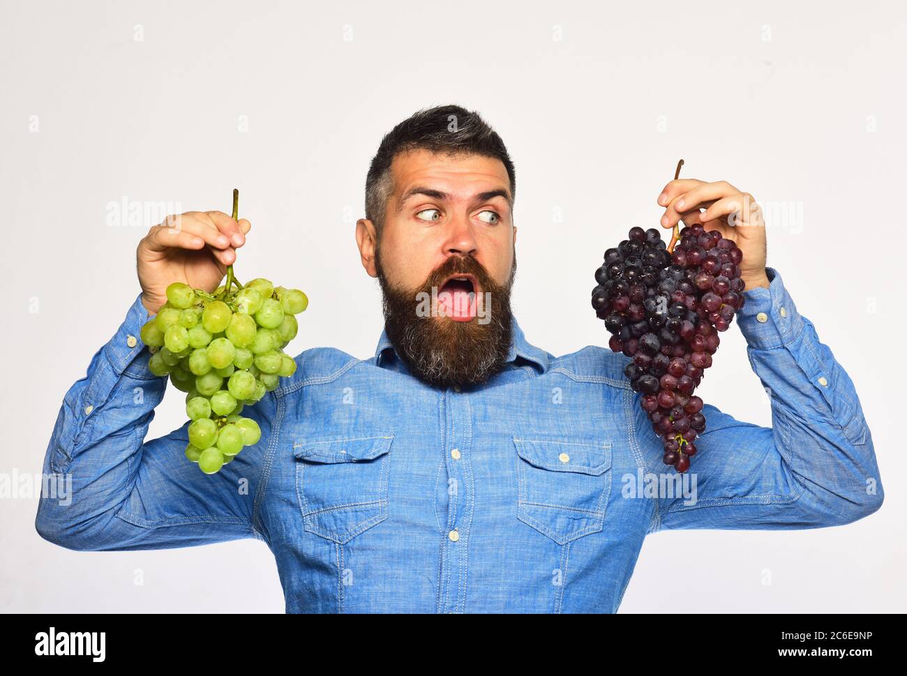 Winemaking and autumn concept. Winegrower with surprised face holds ...
