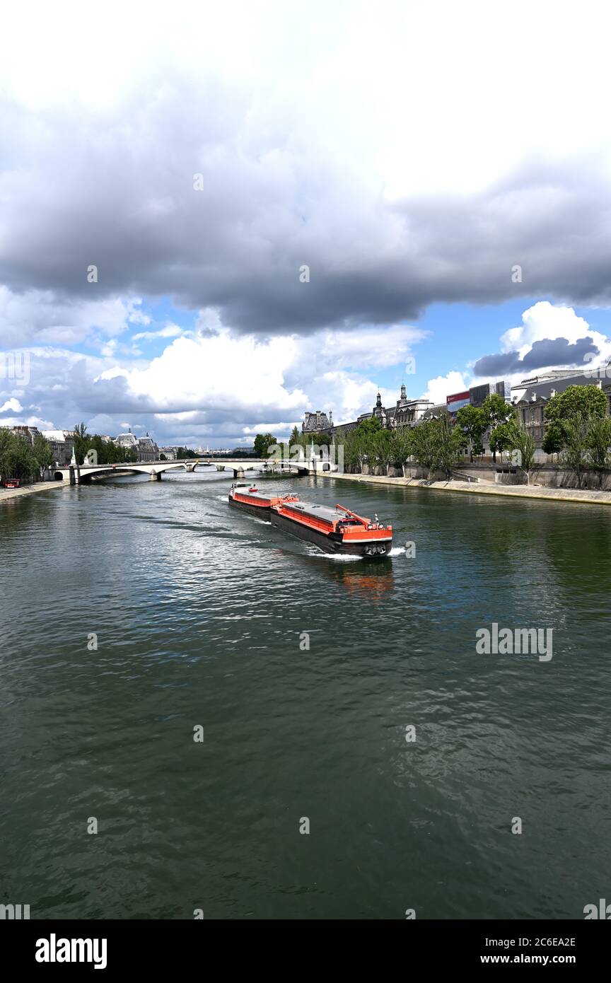 Bridge over the Seine river. A huge barge is passing under the brige ...