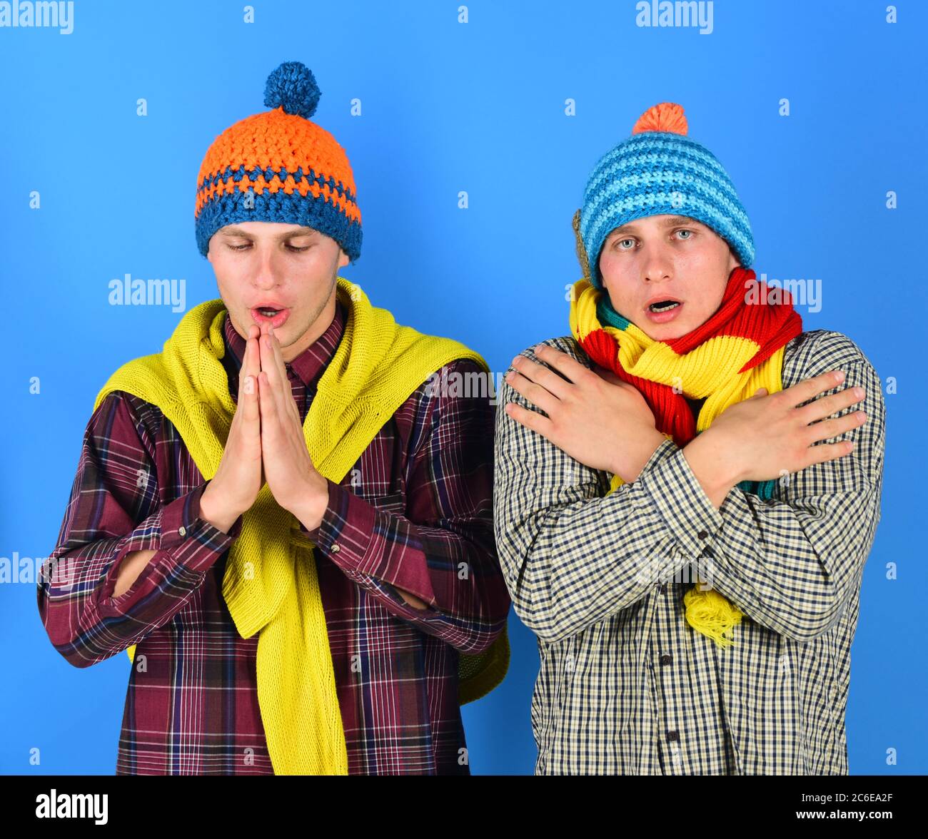 Men with sad faces on blue background. Siblings suffer from freezing ...