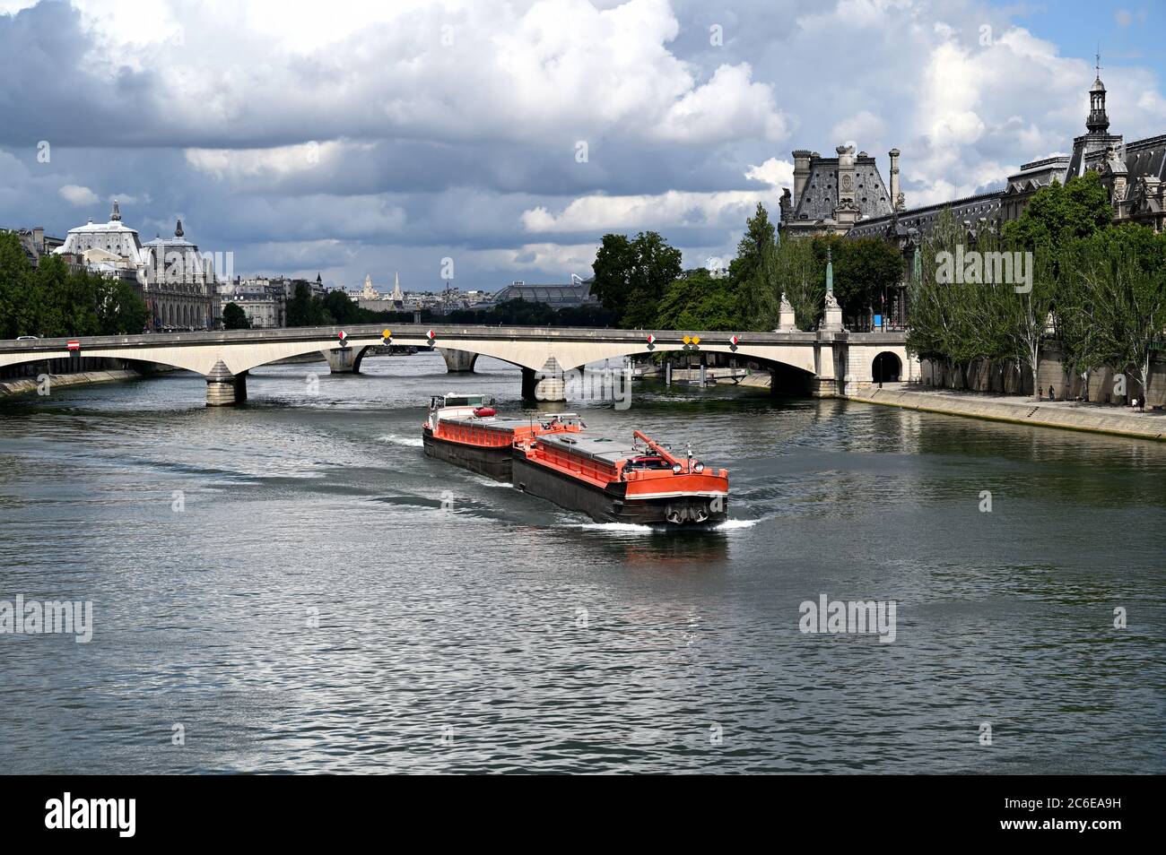 Bridge over the Seine river. A huge barge is passing under the brige ...