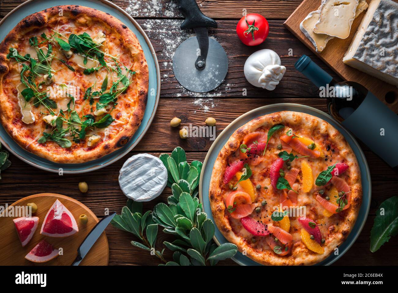 Two pizza on platters which is on wooden background, top view and copy ...