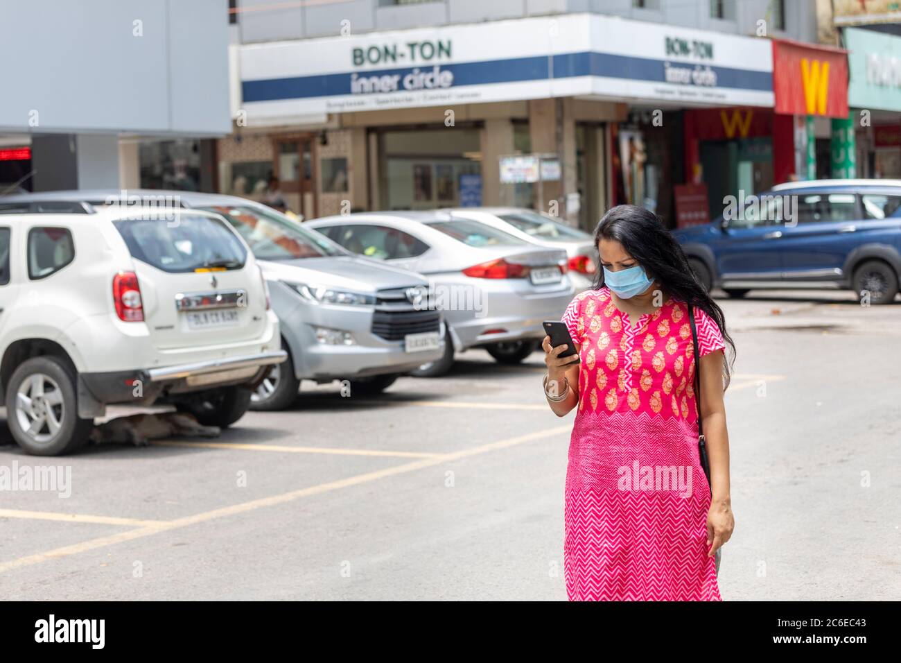 Indian lady wearing face mask uses her phone, Indian woman goes out in ...