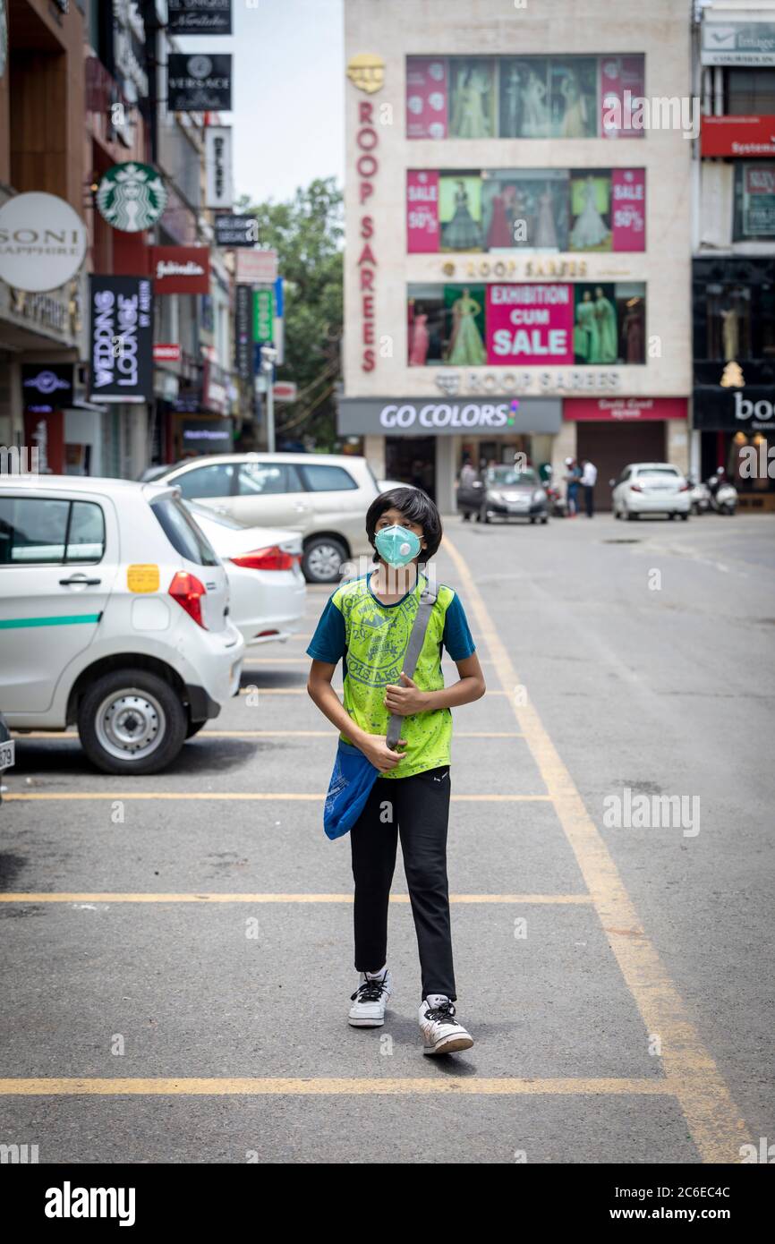 Young Indian boy wearing face mask goes out shopping in local market in ...