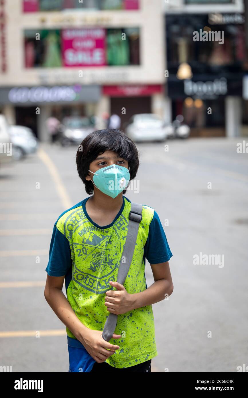 Young Indian boy wearing face mask goes out shopping in local market in ...