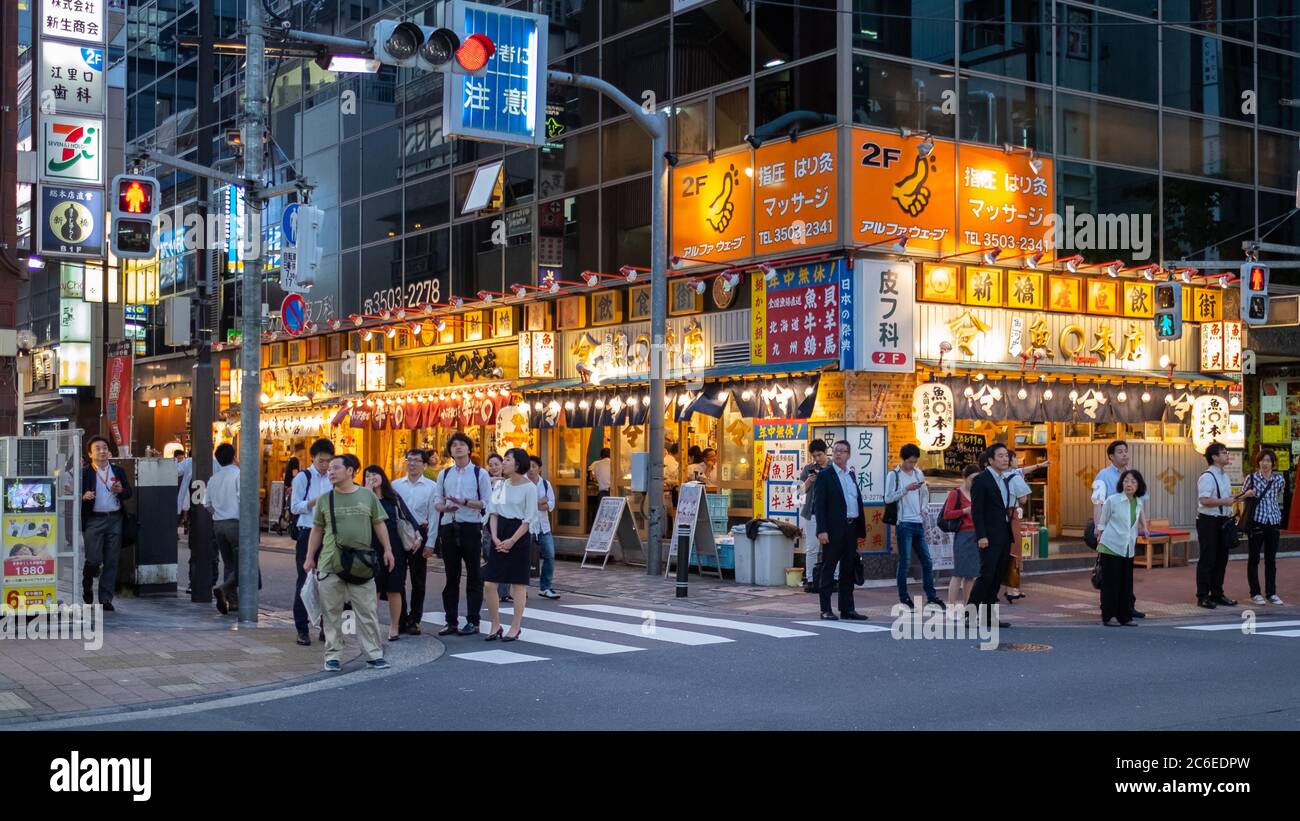 People walking at the back alley street of Shimbashi, a popular after ...