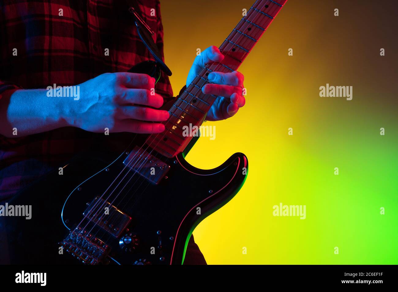 Close up young inspired and expressive musician, guitarist performing ...