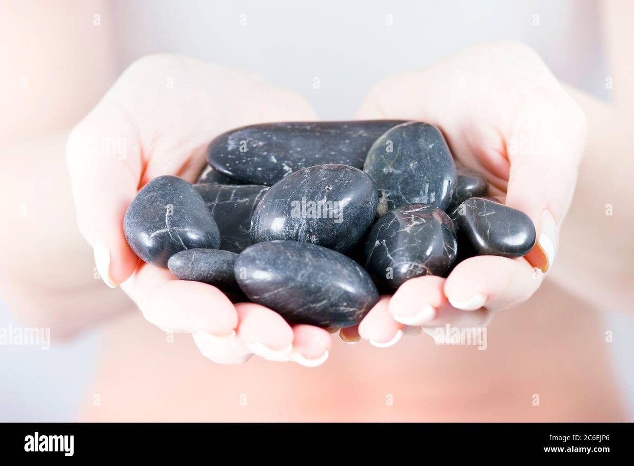 Female hands holding stones Stock Photo - Alamy