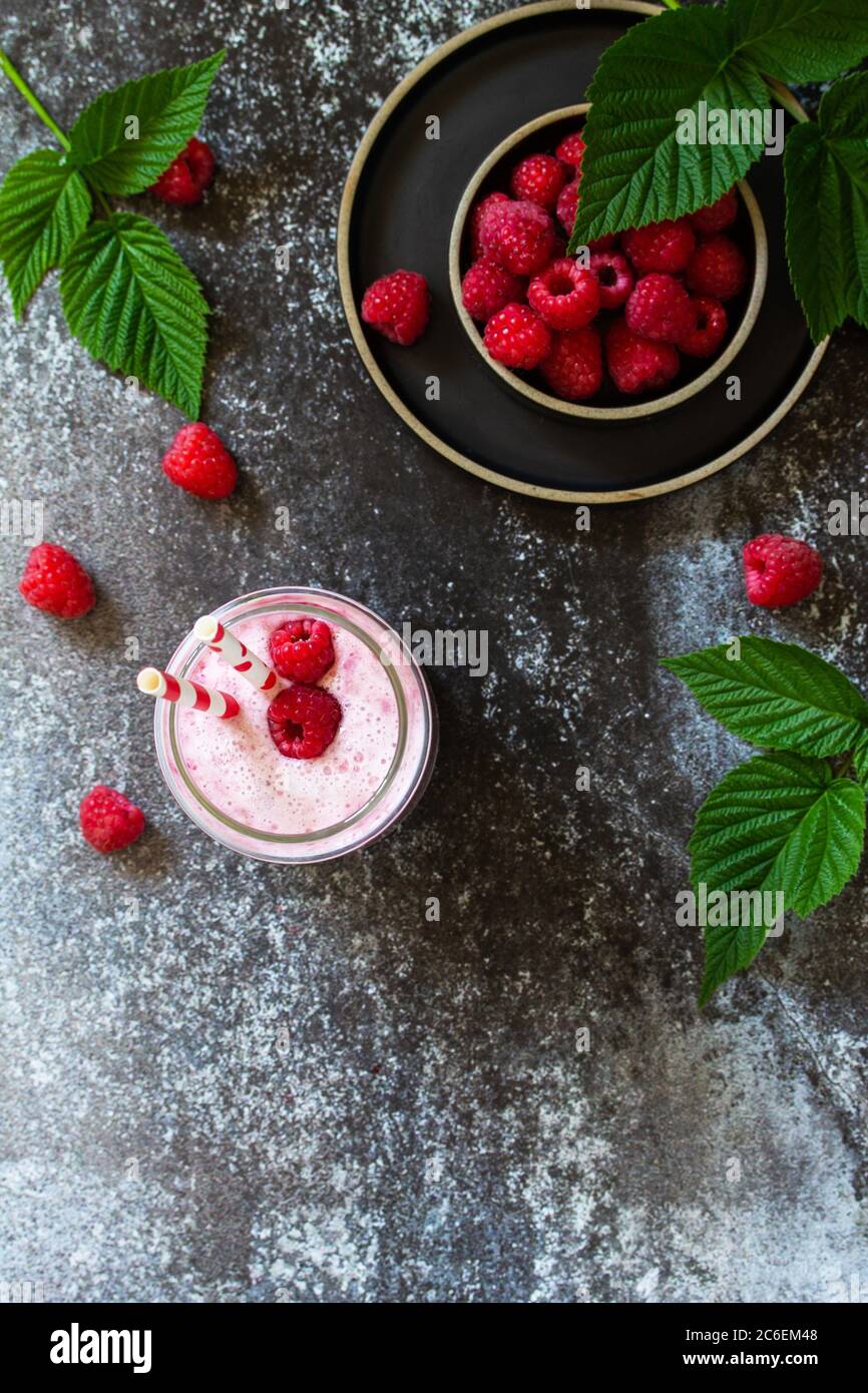 Summer cool milkshake. Raspberry protein shake in glass on a dark ...