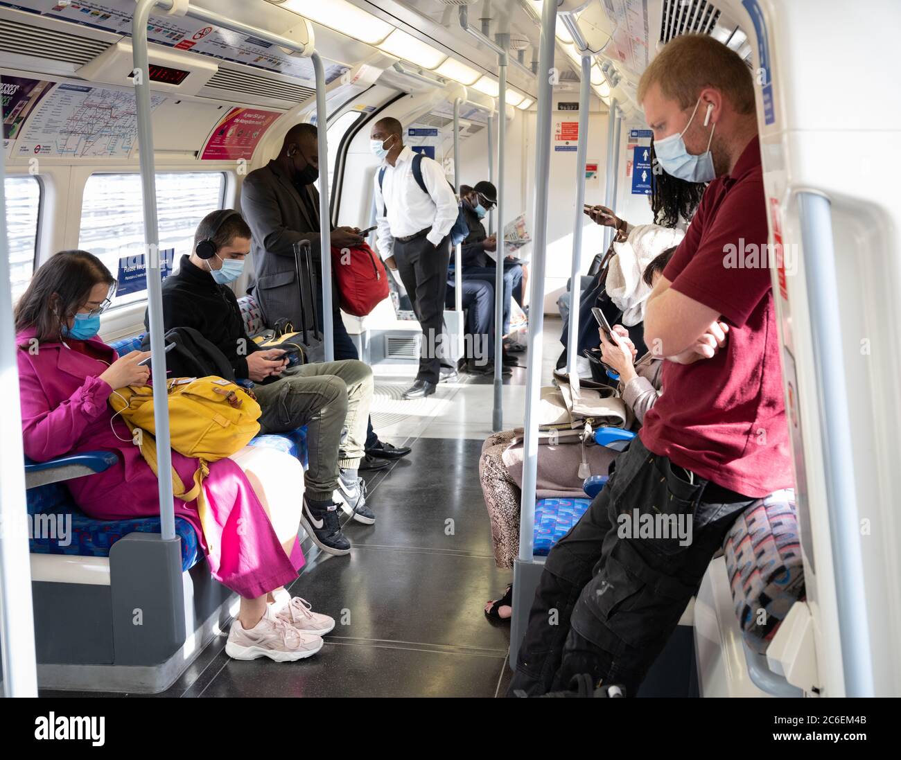 Commuters wearing face masks on jubilee line hi-res stock photography ...