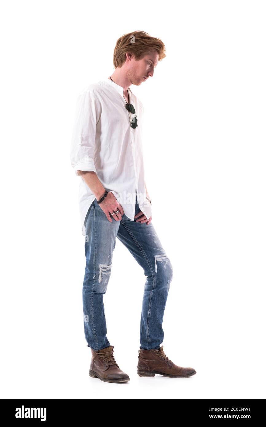 Side view of sad disappointed young casual man looking down with bowed ...