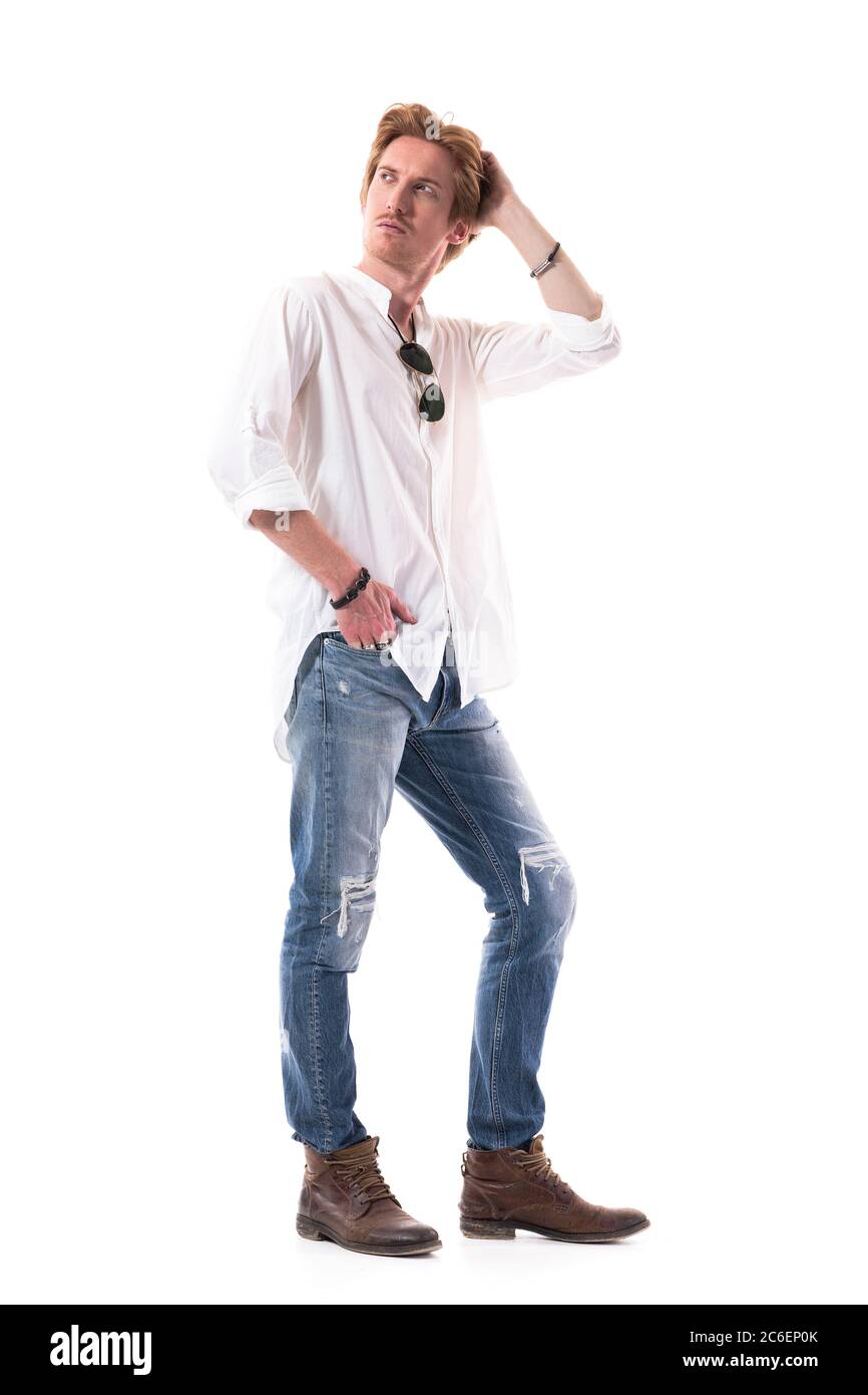 Side view of puzzled serious young stylish man looking up behind over ...