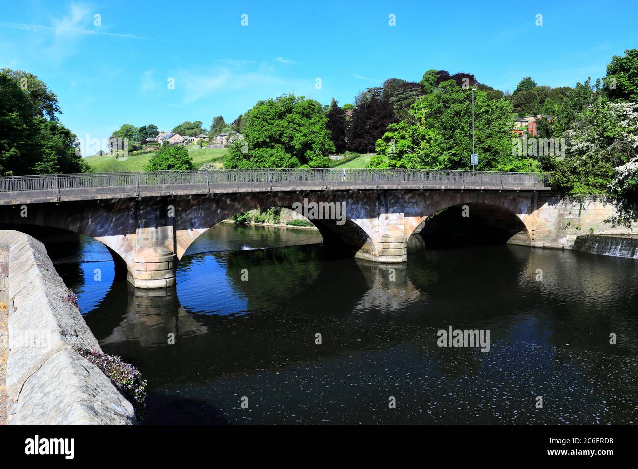 Spring view of the Belper bridge and weir, river Derwent, Belper town ...