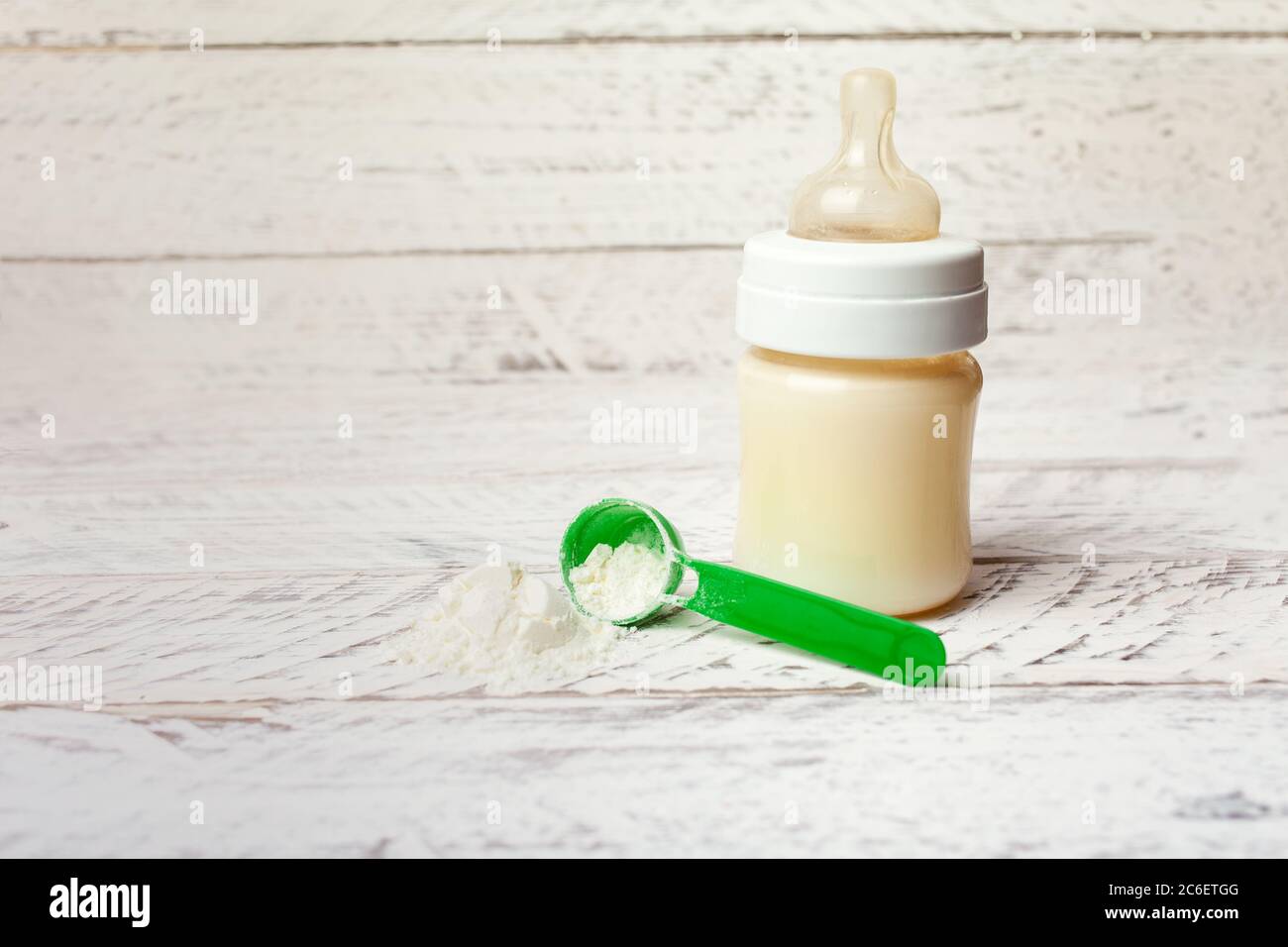 Baby bottle with milk formula on a white wooden background with empty ...