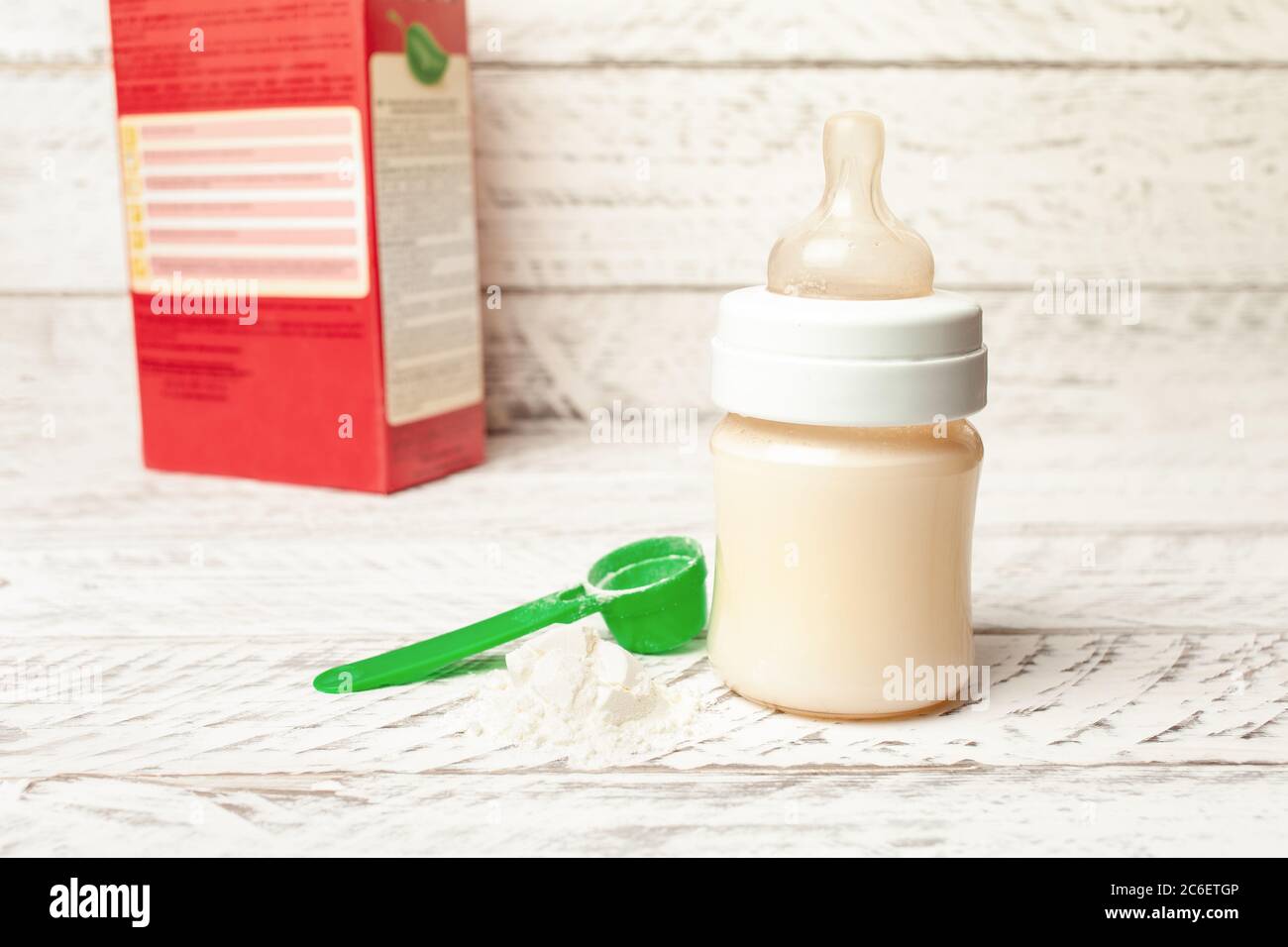 Baby bottle with milk formula on a white wooden background with empty ...