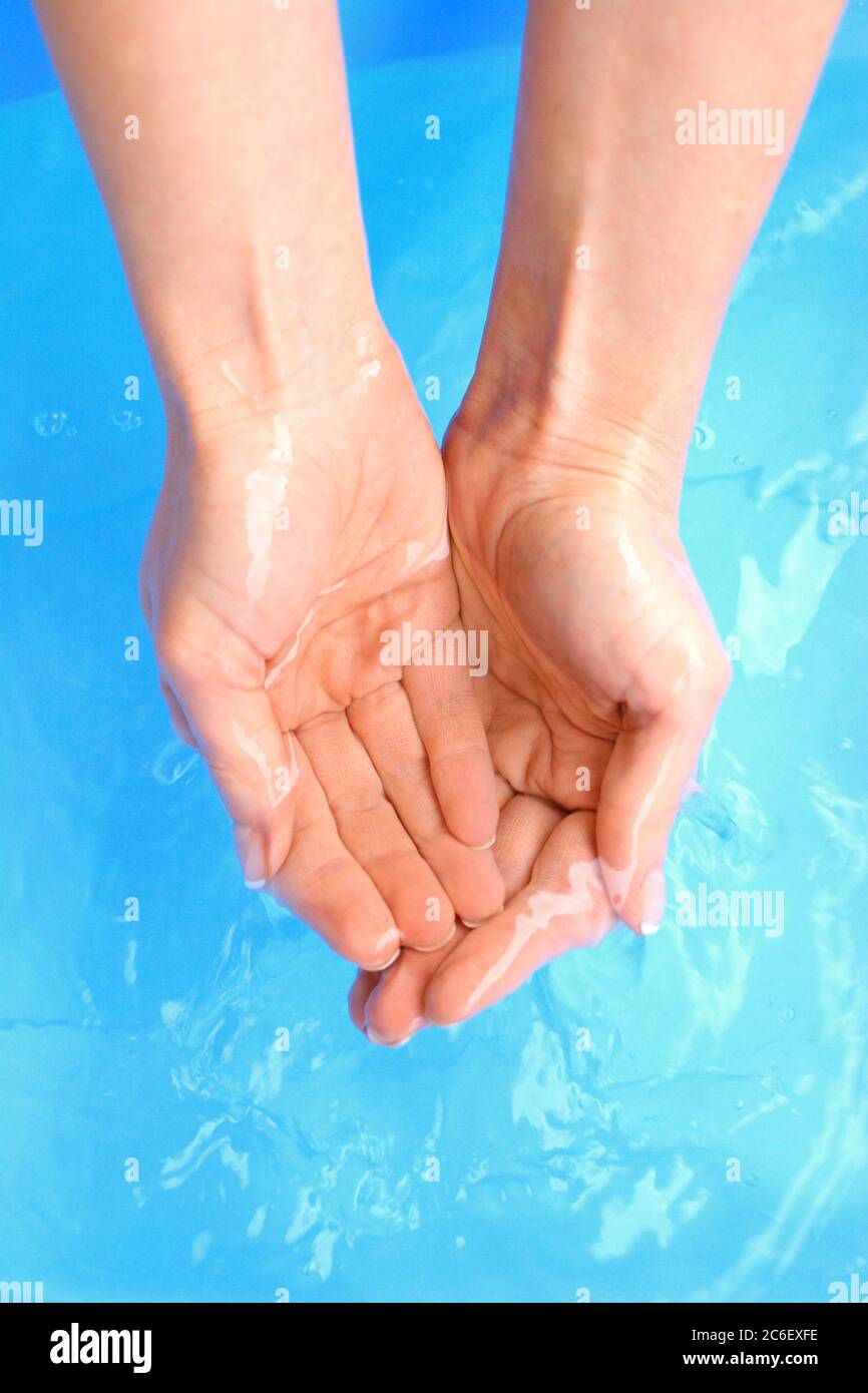 Washing hands in water, macro, blue background Stock Photo - Alamy