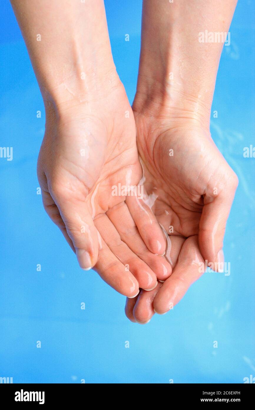 Washing hands in water, macro, blue background Stock Photo - Alamy