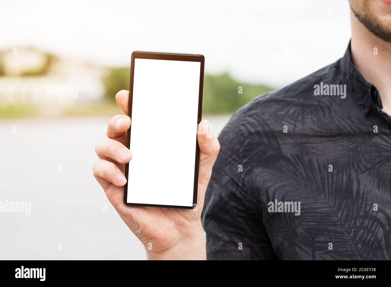 Image of mans hand holding modern black mobile phone with blank white ...