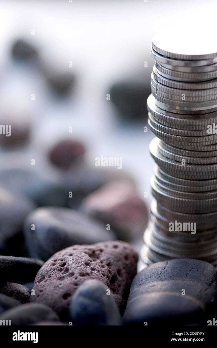 Coin stacks on a white background with stones - macro depth of field ...