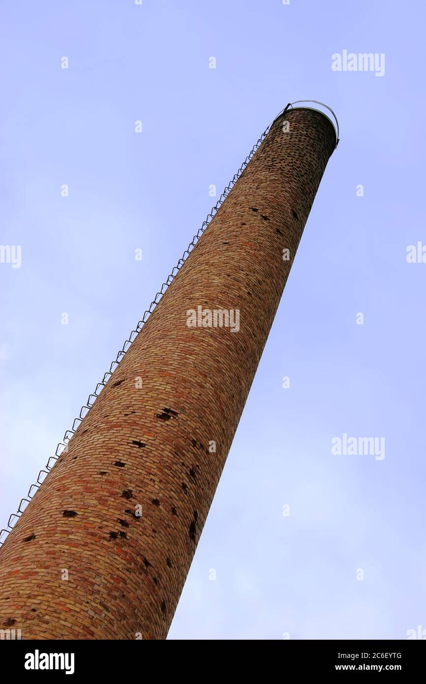 Old weathered tall industrial factory chimney, red grungy brick ...