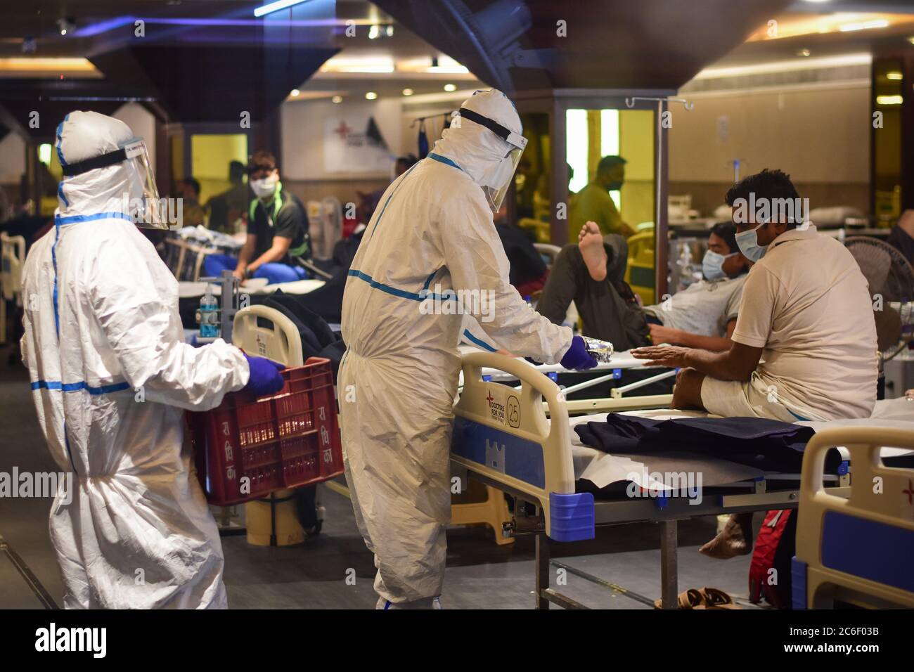 Health workers wearing protective gear distribute lunch boxes to Covid ...