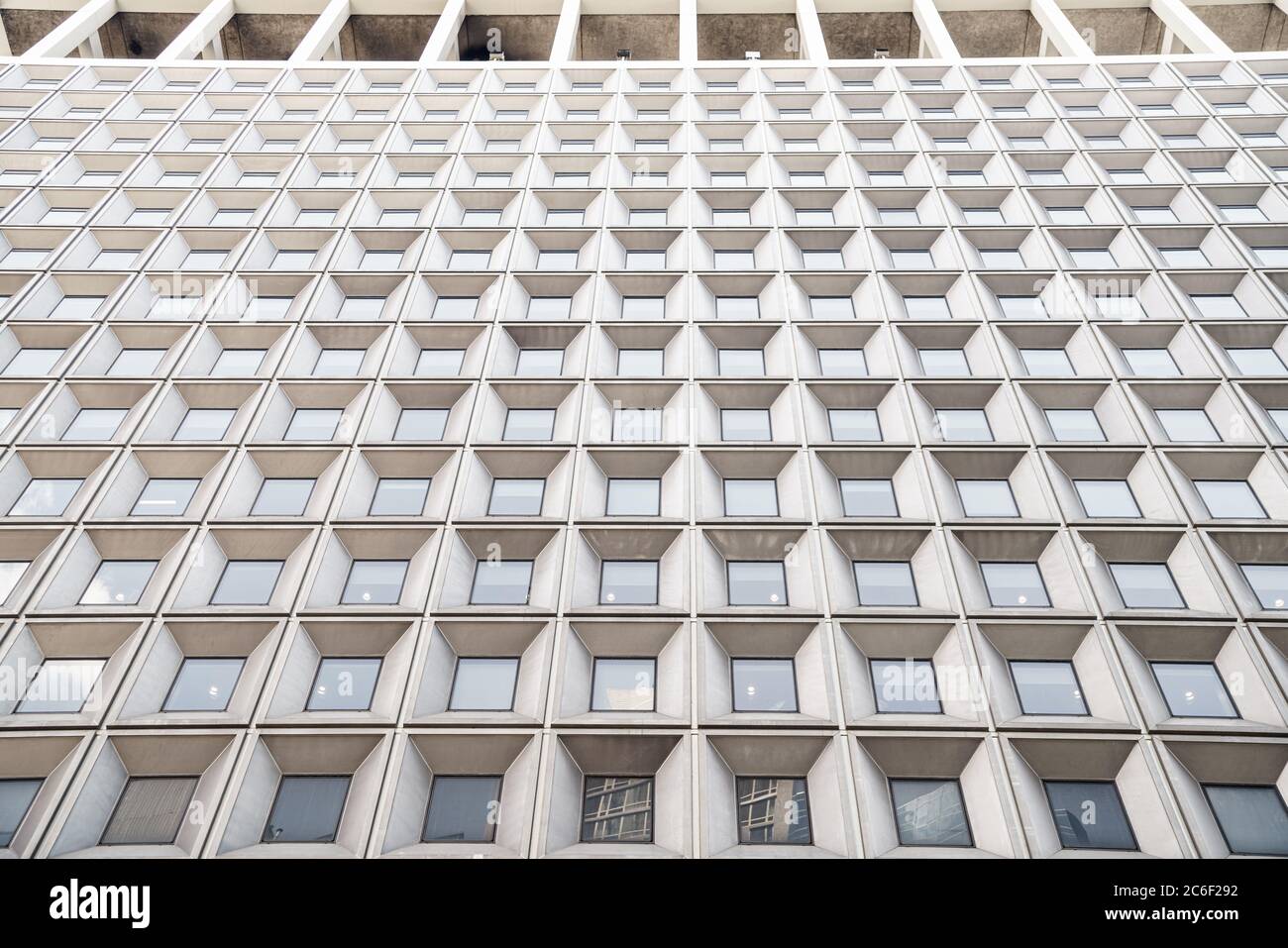 Low angle view of the square windows of a white building lit by ...
