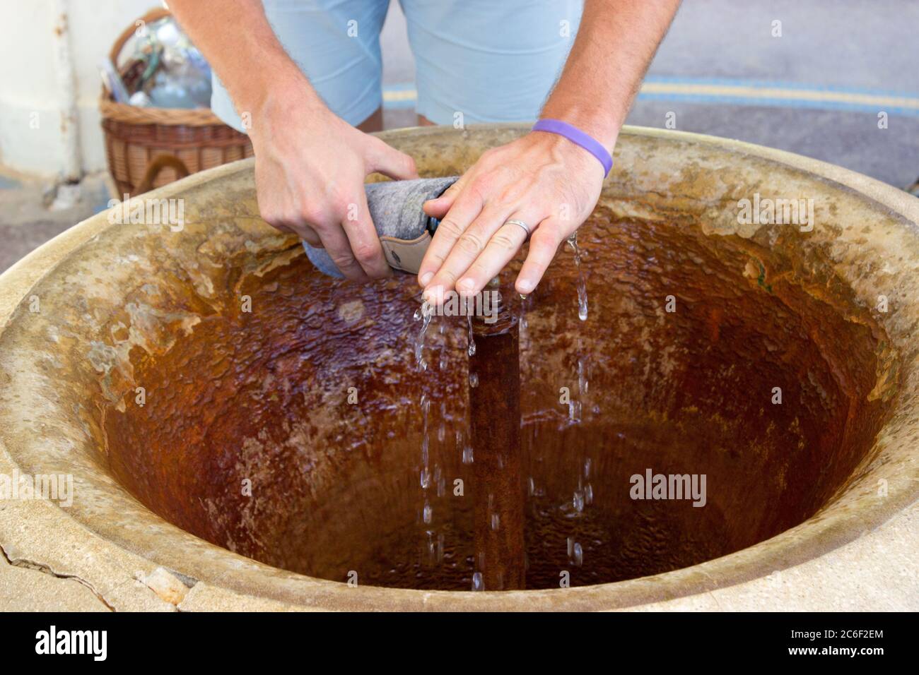 Scooping mineral water with his hands into a bottle in a spa Stock ...