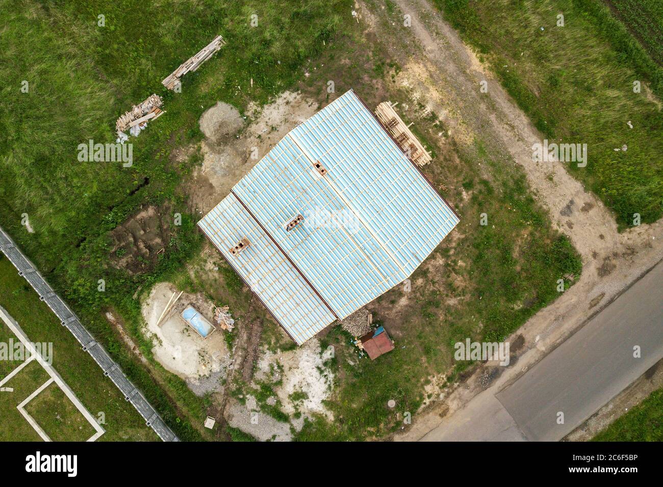Top down aerial view of a brick house with wooden roof frame under ...