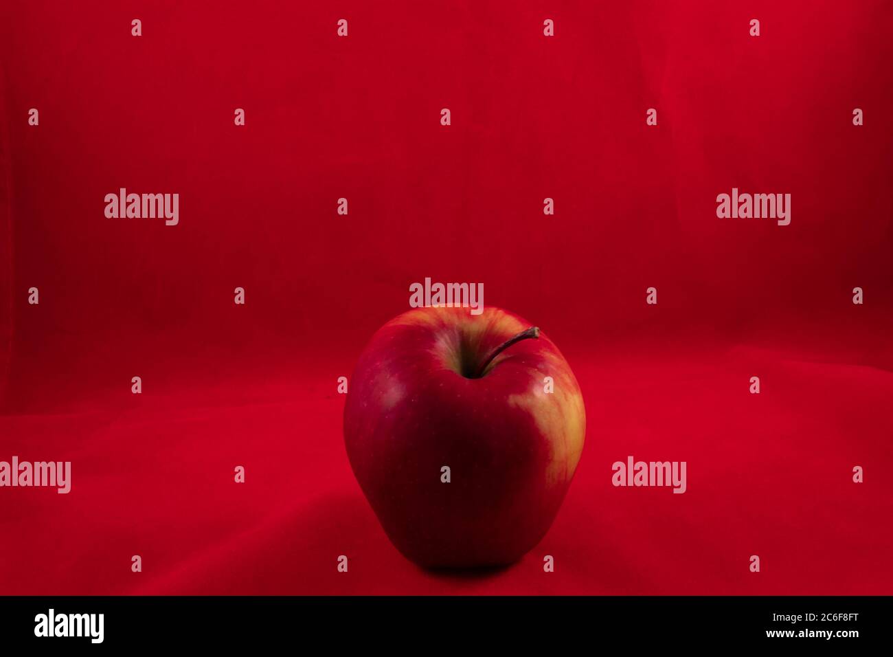 one delicious shiny apple on a red studio background Stock Photo - Alamy