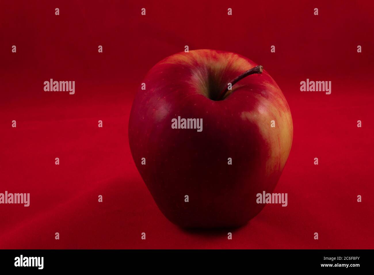 one delicious shiny apple on a red studio background Stock Photo - Alamy