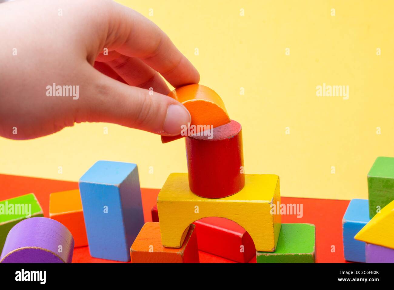 hand building tower with colorful building blocks Stock Photo - Alamy