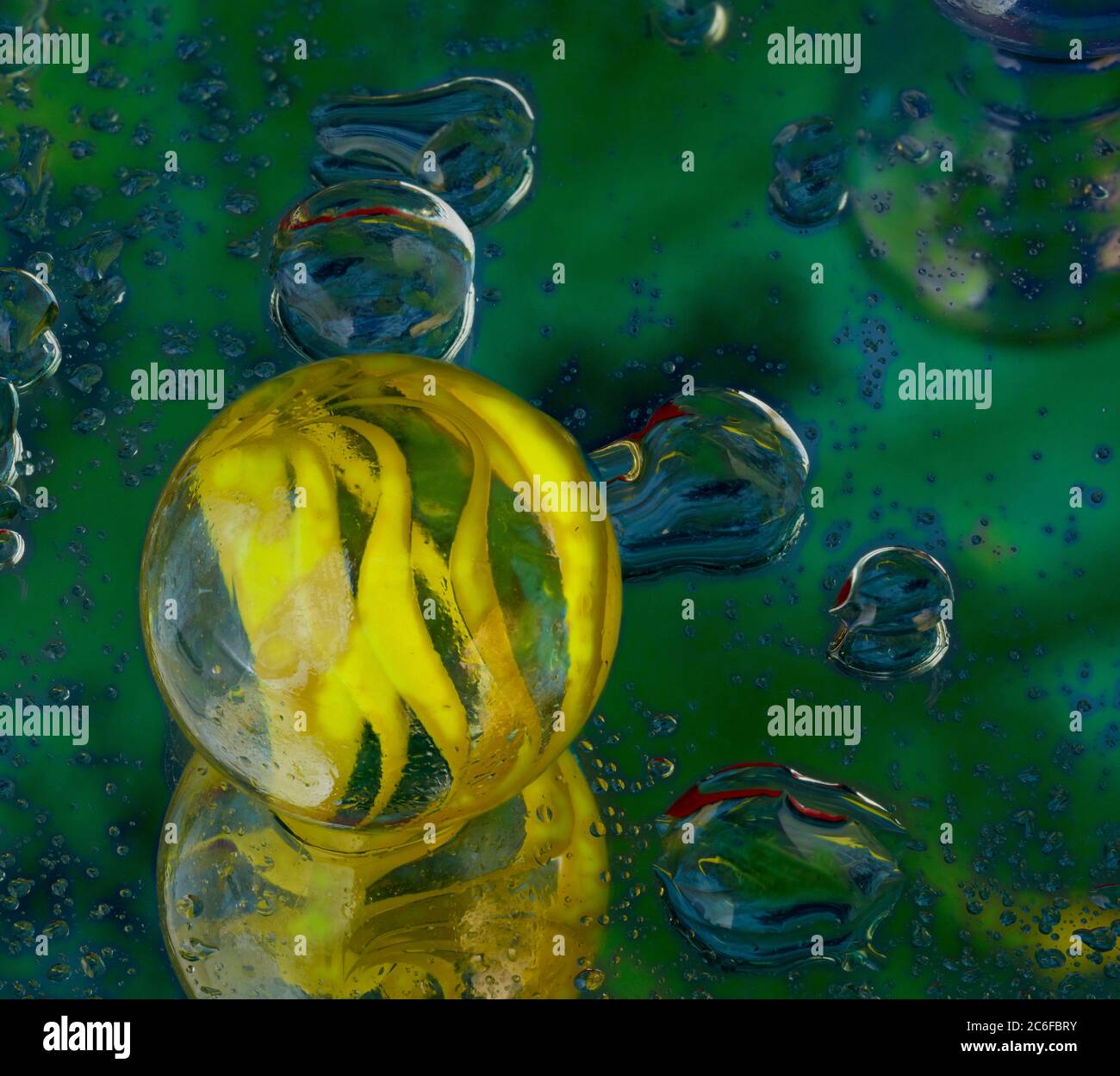 Single glass marble and reflection with a colour infused background and ...