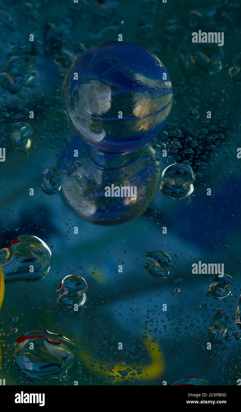 Single glass marble and reflection with a colour infused background and ...