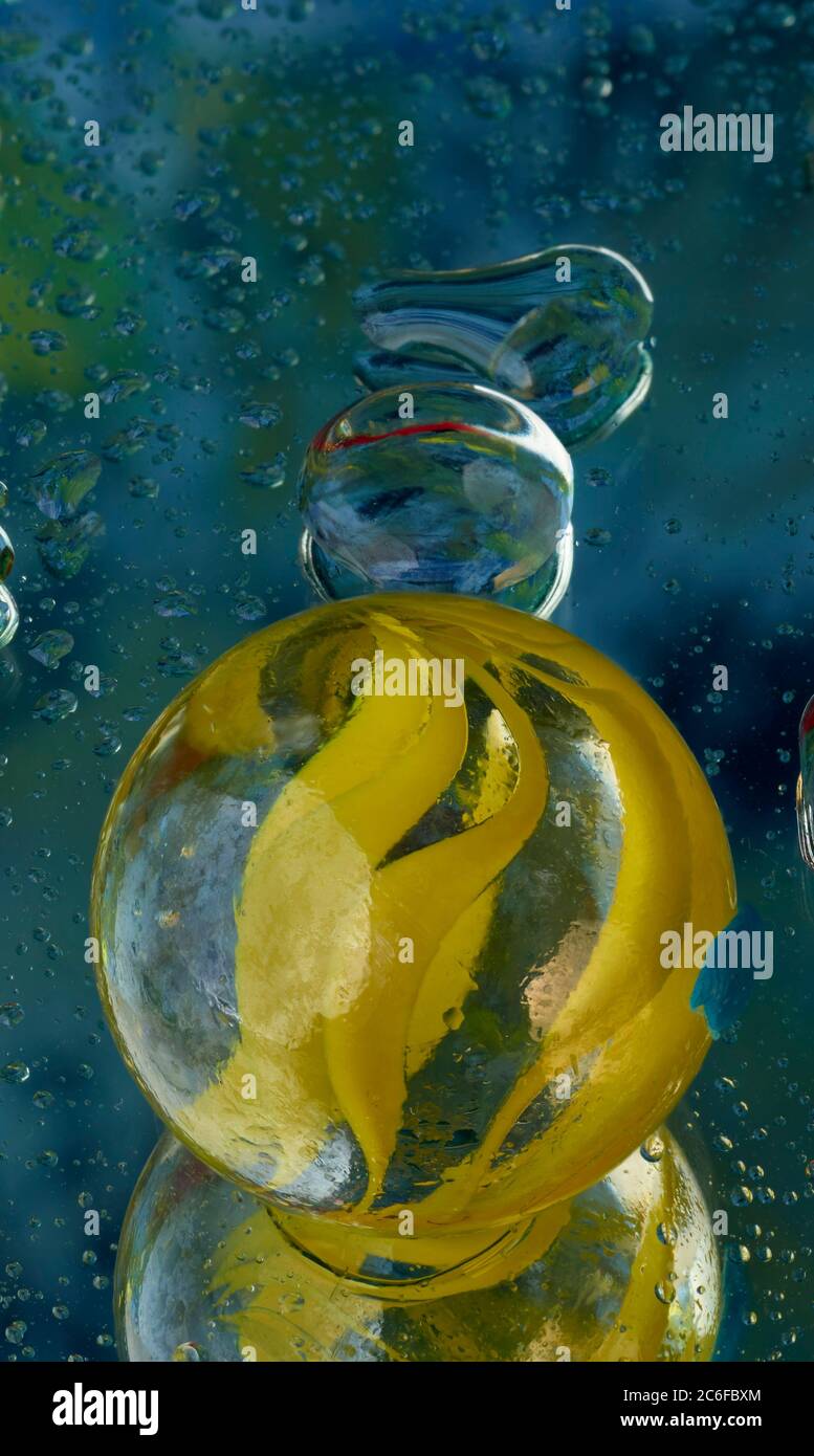 Single glass marble and reflection with a colour infused background and ...