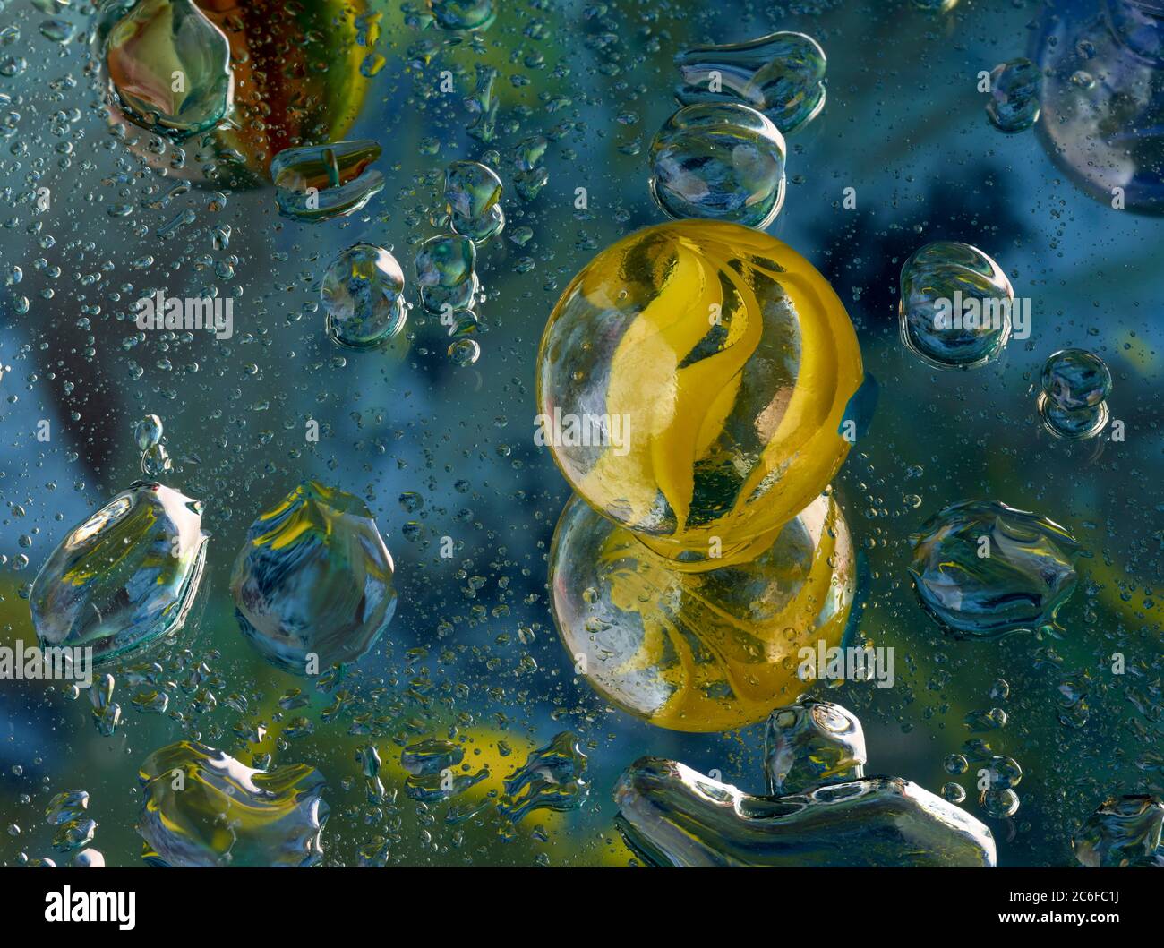 Single glass marble and reflection with a colour infused background and ...