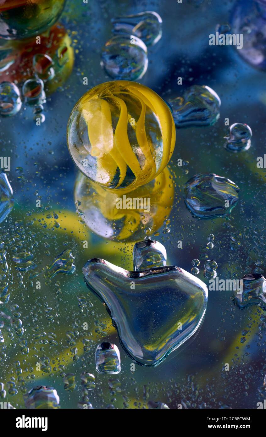 Single glass marble and reflection with a colour infused background and ...