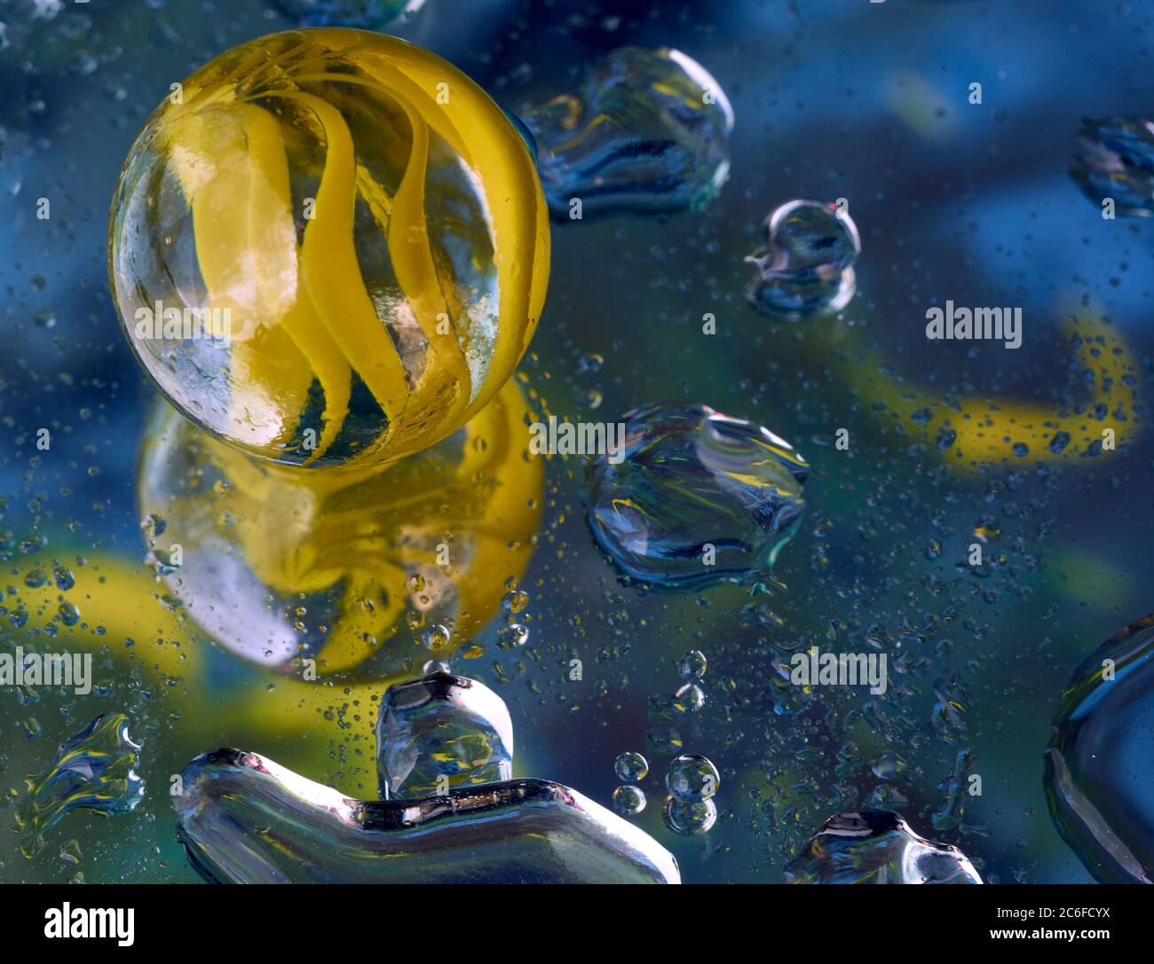 Single glass marble and reflection with a colour infused background and ...