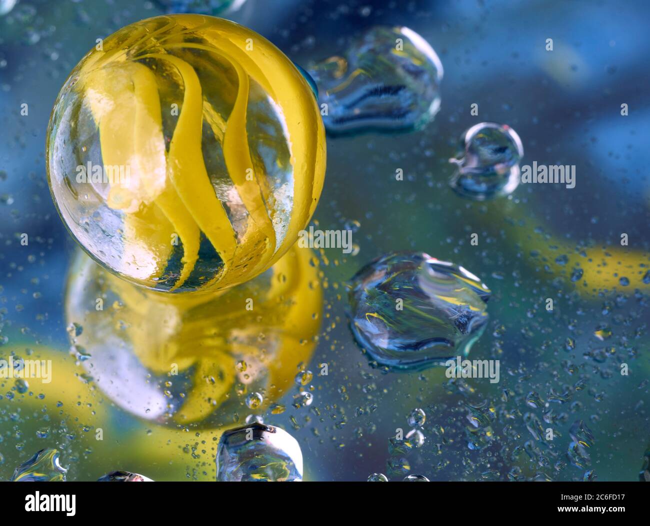 Single glass marble and reflection with a colour infused background and ...