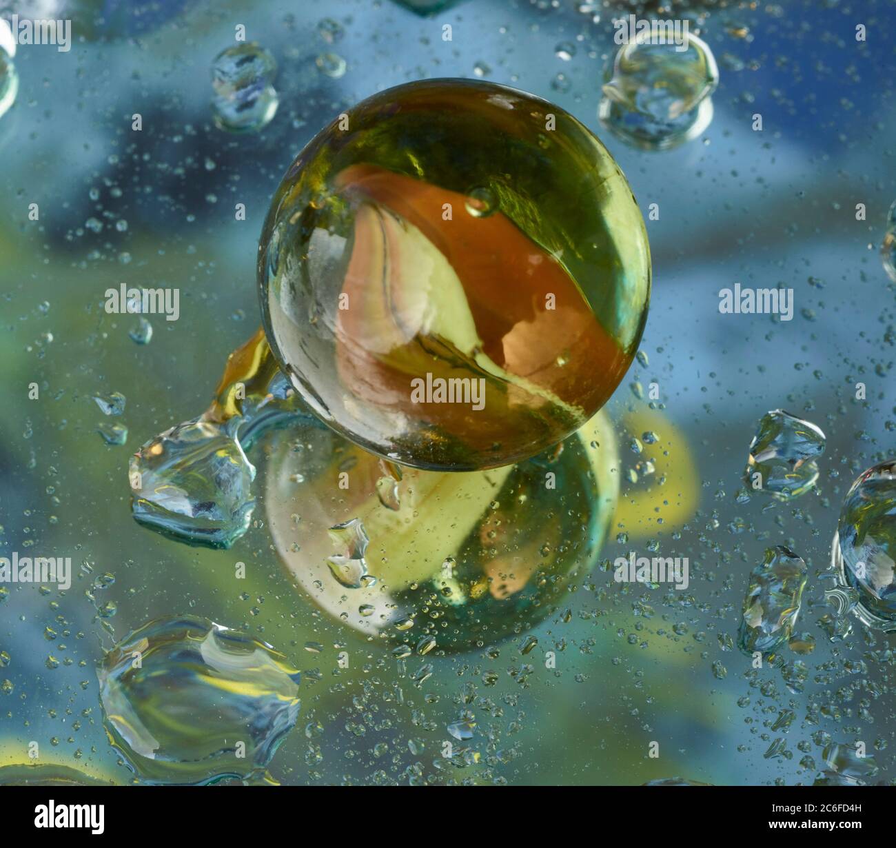 Single glass marble and reflection with a colour infused background and ...