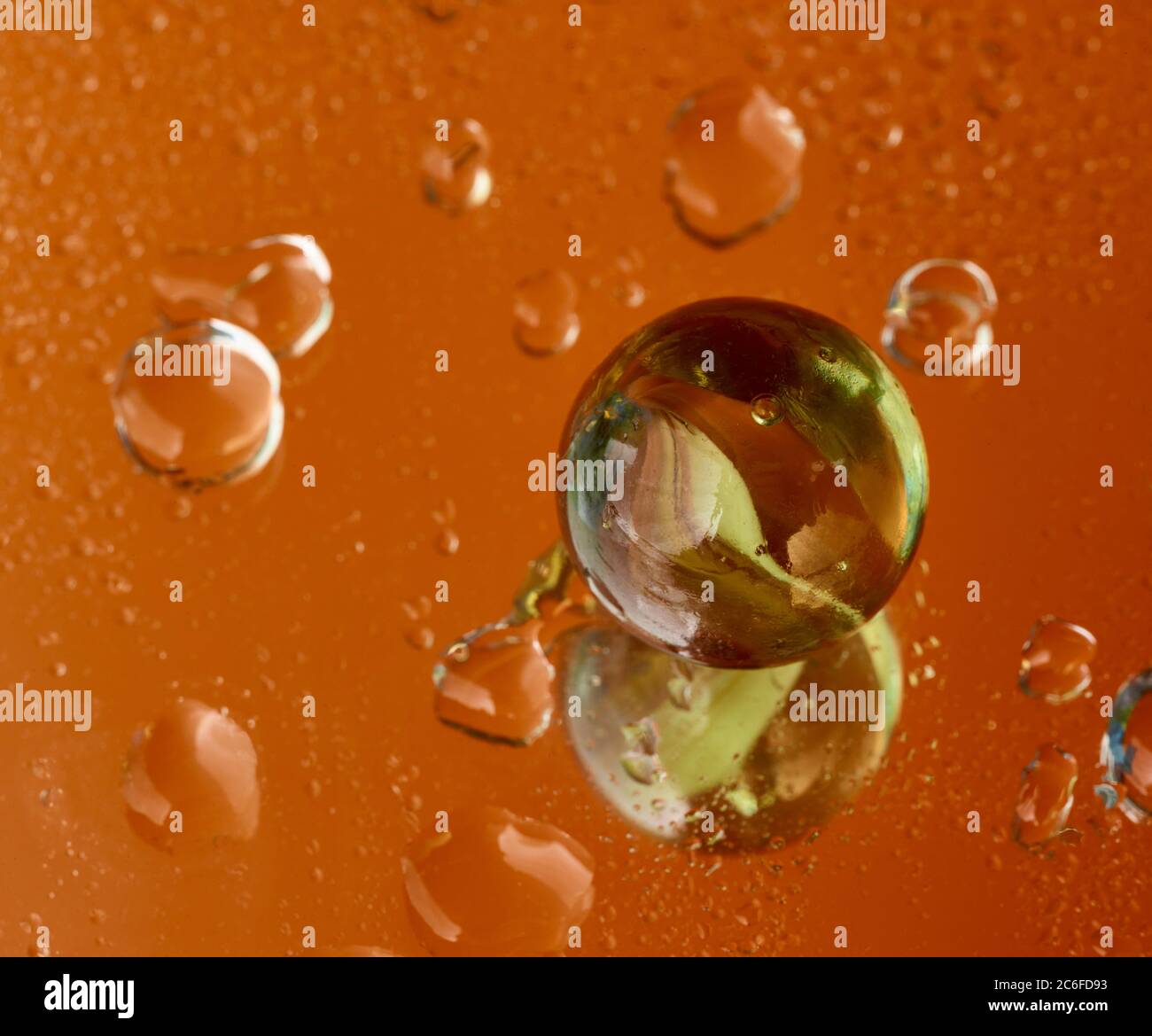 Single glass marble and reflection with a colour infused background and ...