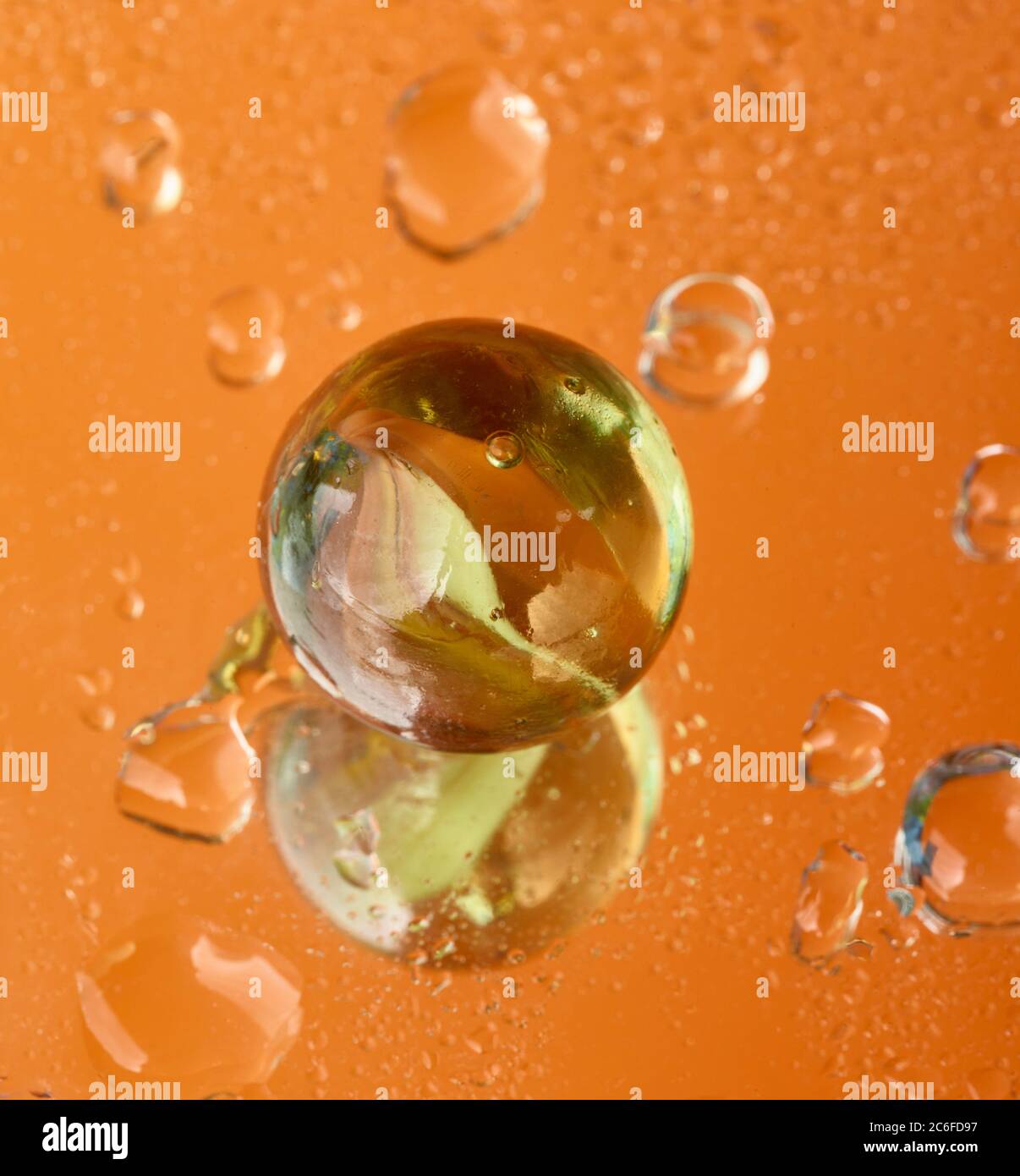 Single glass marble and reflection with a colour infused background and ...