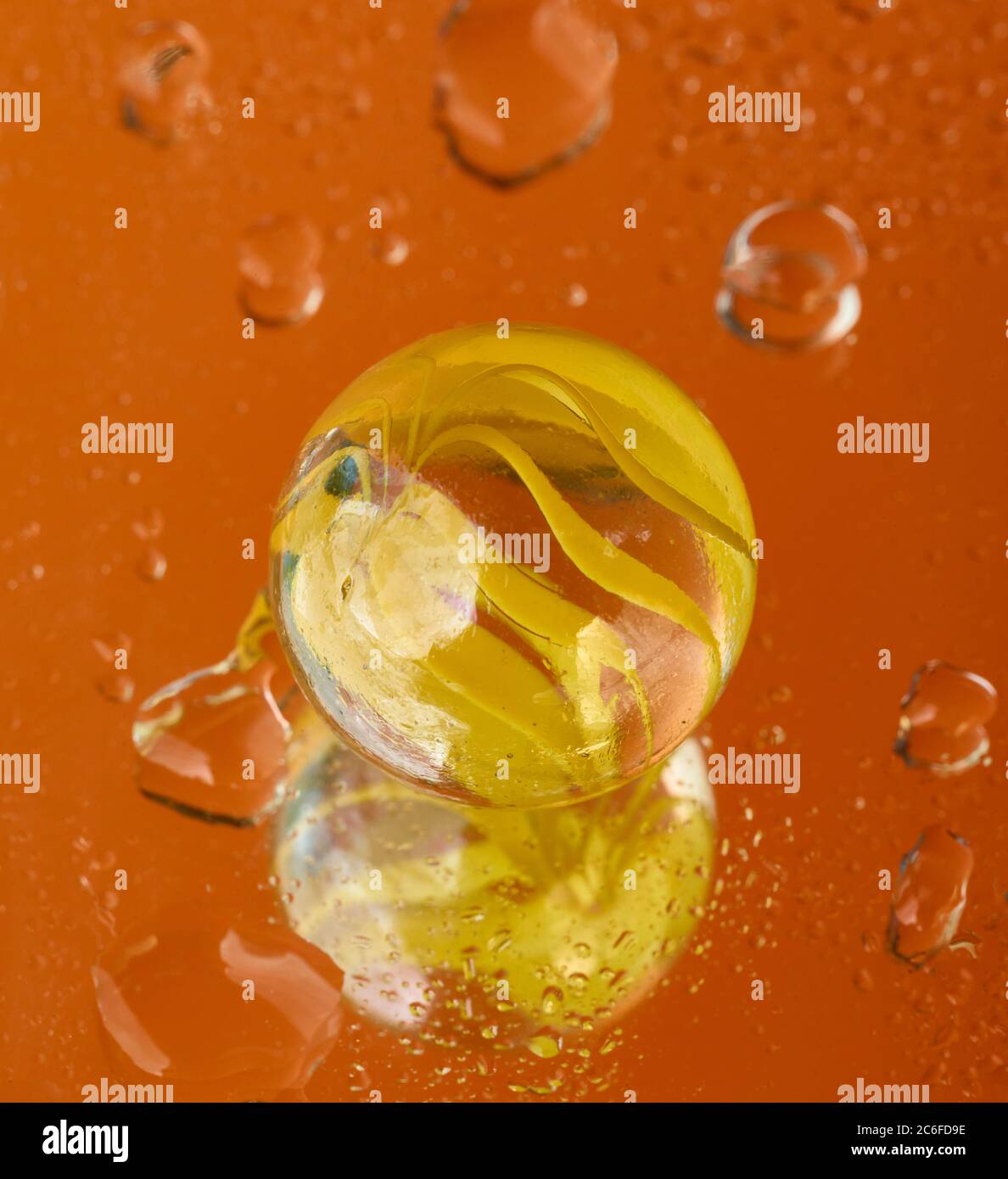 Single glass marble and reflection with a colour infused background and ...