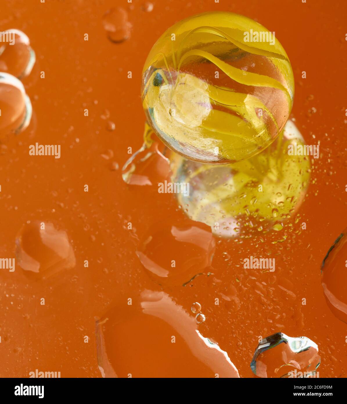 Single glass marble and reflection with a colour infused background and ...