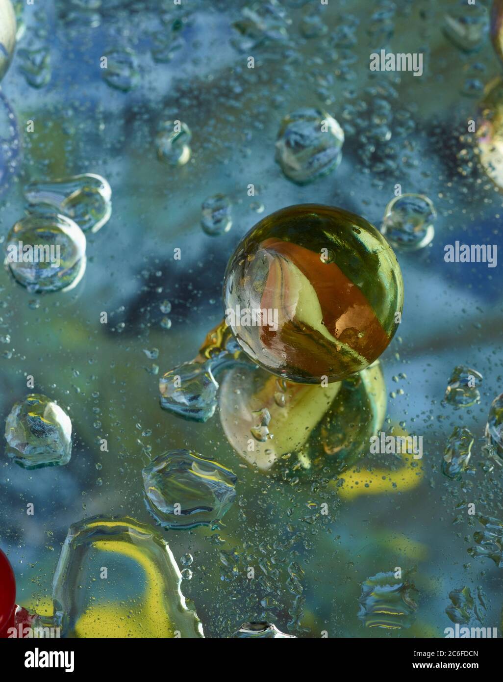 Single glass marble and reflection with a colour infused background and ...