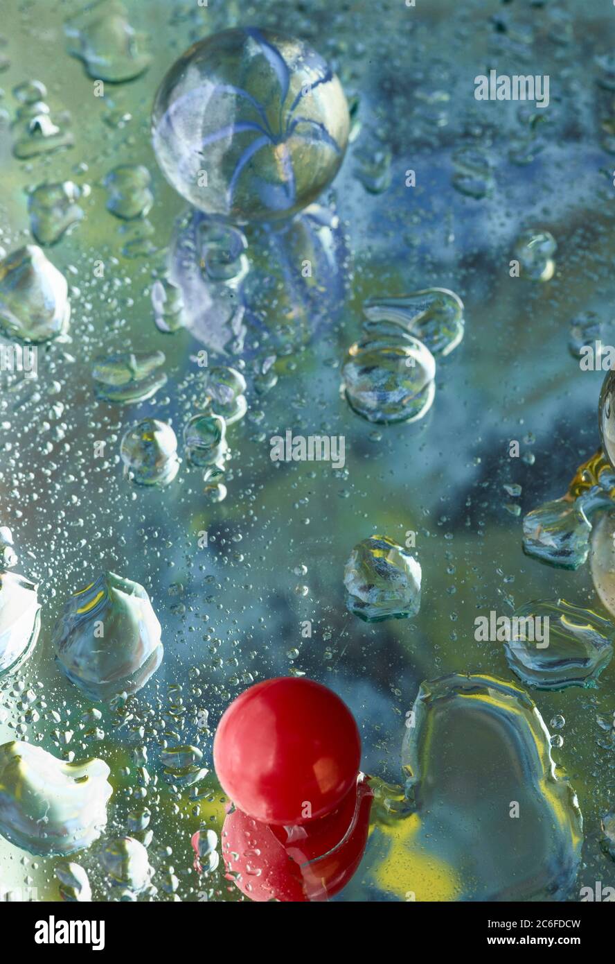 Single glass marble and reflection with a colour infused background and ...