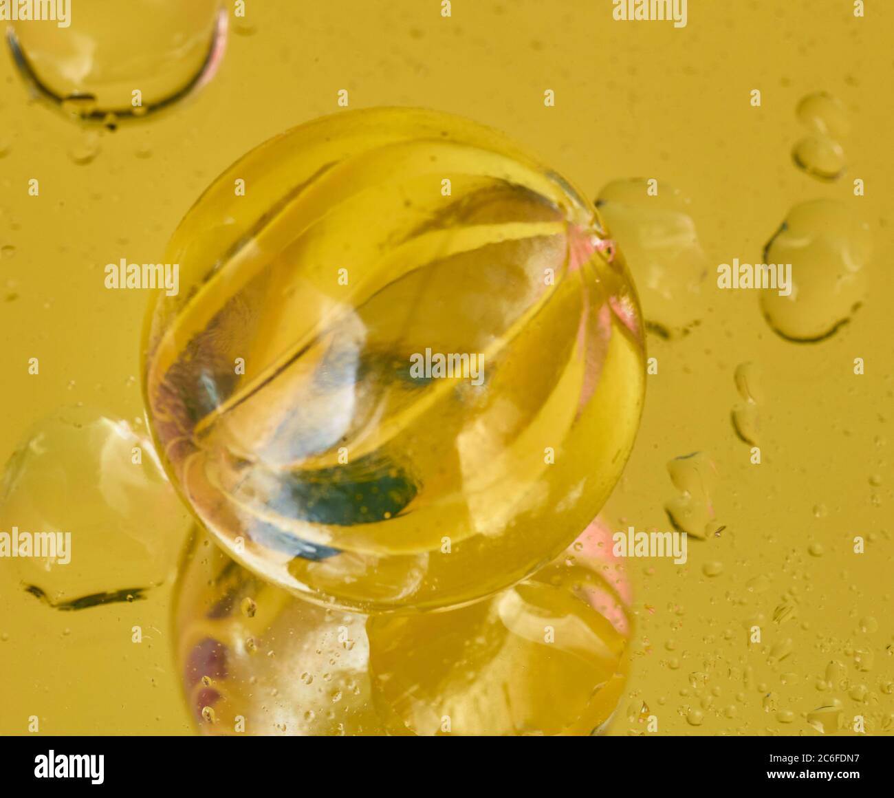 Single glass marble and reflection with a colour infused background and ...