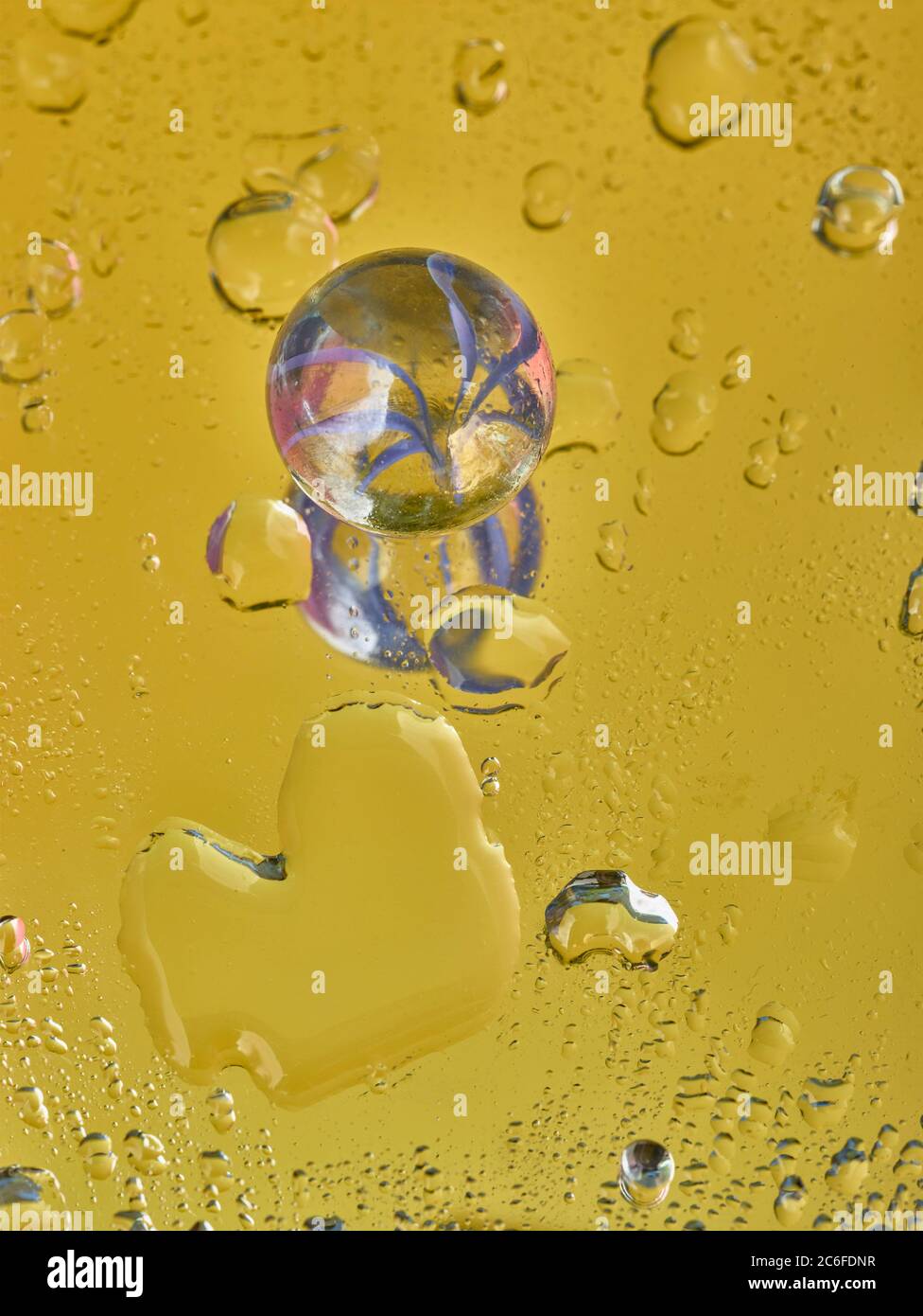 Single glass marble and reflection with a colour infused background and ...