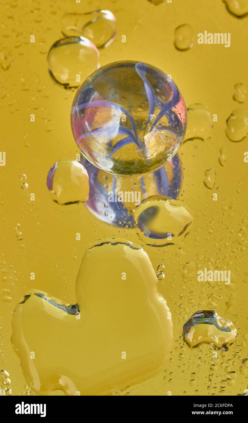 Single glass marble and reflection with a colour infused background and ...