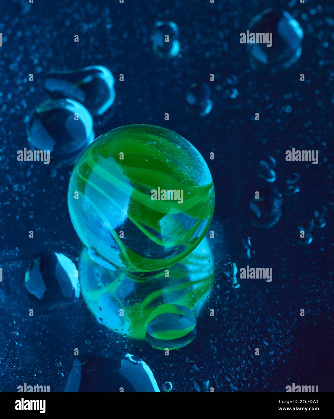 Single glass marble and reflection with a colour infused background and ...