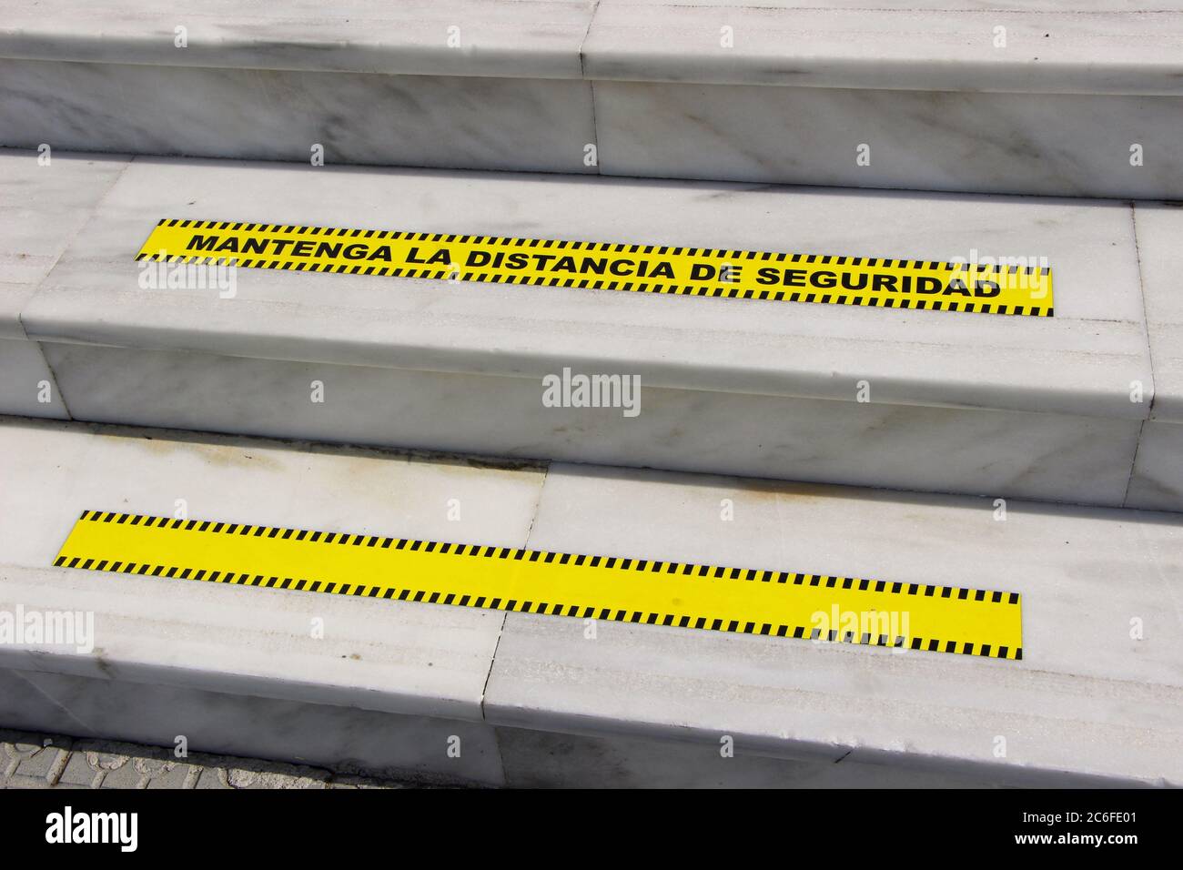 Yellow warning stickers to keep your distance on the marble steps to ...